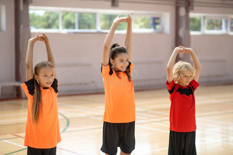 Three Kids Doing Stretching in the Gym Stock Photo - Image of orange ...
