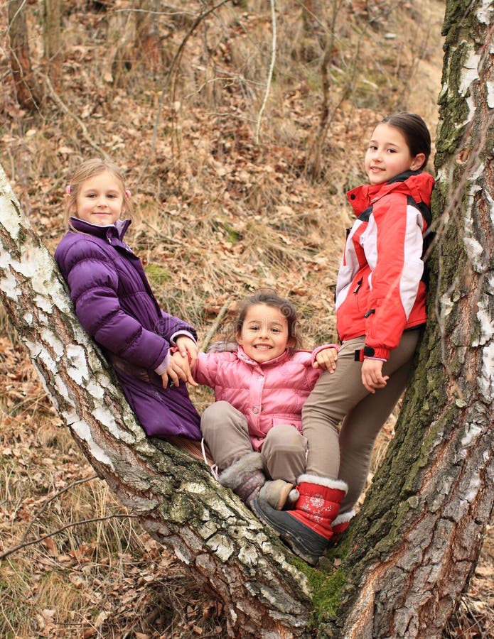 Three Kids - Girls Leaning on Tree Stock Photo - Image of leaning ...
