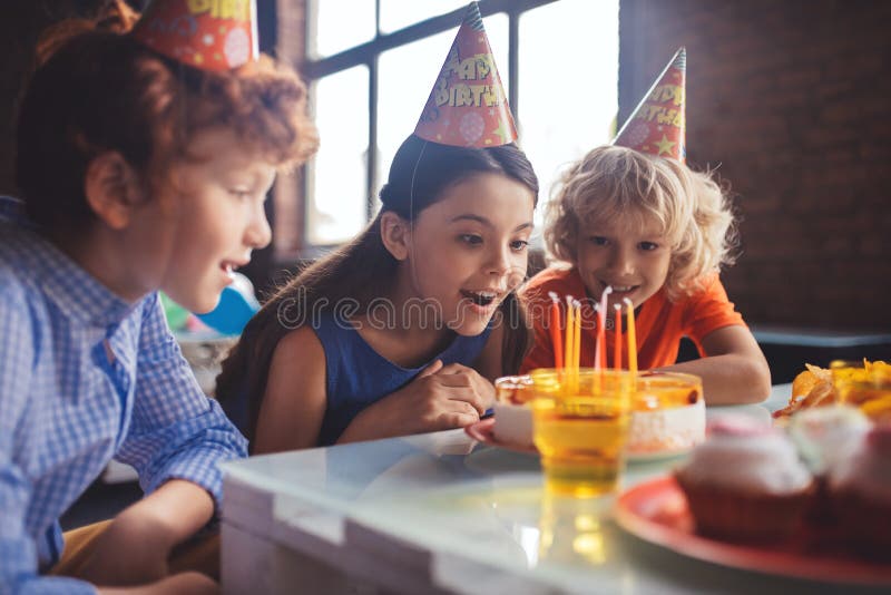 Three Kids Looking at the Cake and Feeling Amused Stock Photo - Image ...