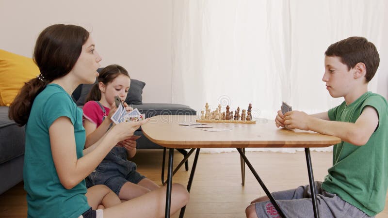Three Kids Playing a Crad Game in the Living Room, Shouting and Arguing ...