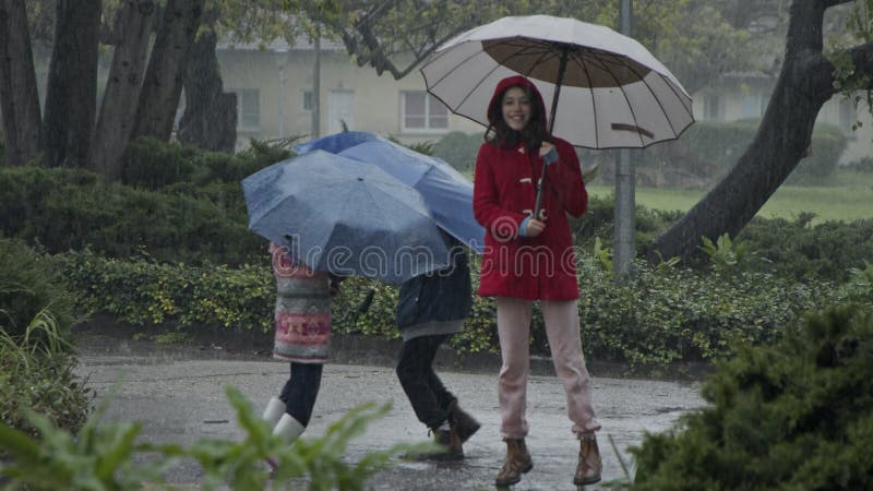 Kids in the Pouring Rain Having Fun Jumping with Umbrellas - Slow ...