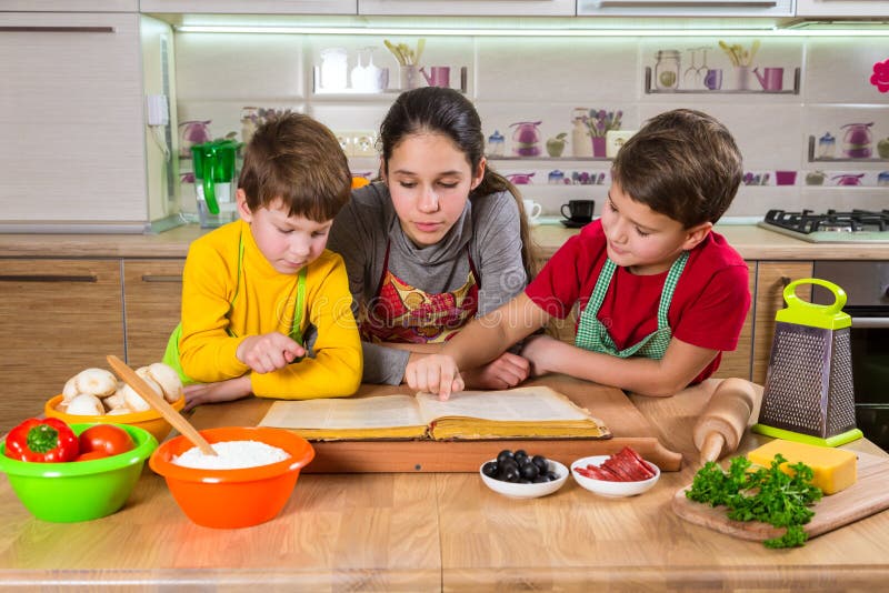 Three Kids Reading the Cook Book, Making the Dinner Stock Image - Image ...