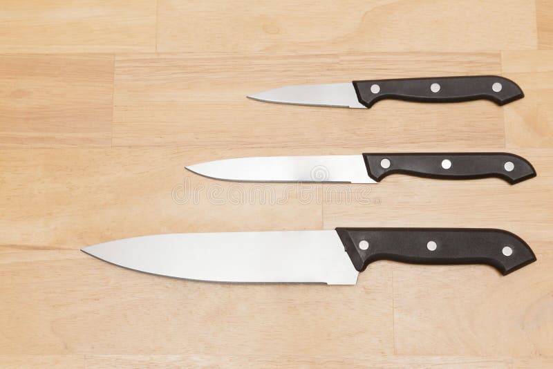 Three Kitchen Knives on Wood Table Stock Photo - Image of stainless ...