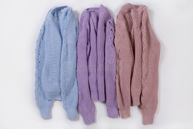 Three Knitted Sweaters in Pastel Colors, Lying Side by Side on a White ...