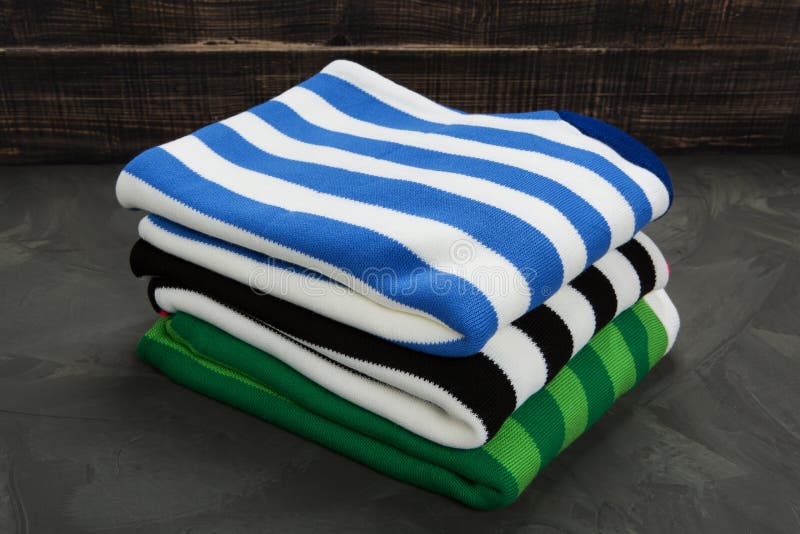 Three Knitted Sweaters, Striped in Different Colors, Folded and Stacked ...