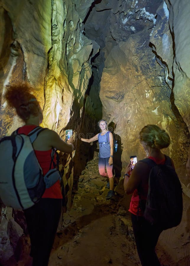 Three Ladies Exploring a Cave Stock Photo - Image of cave ...