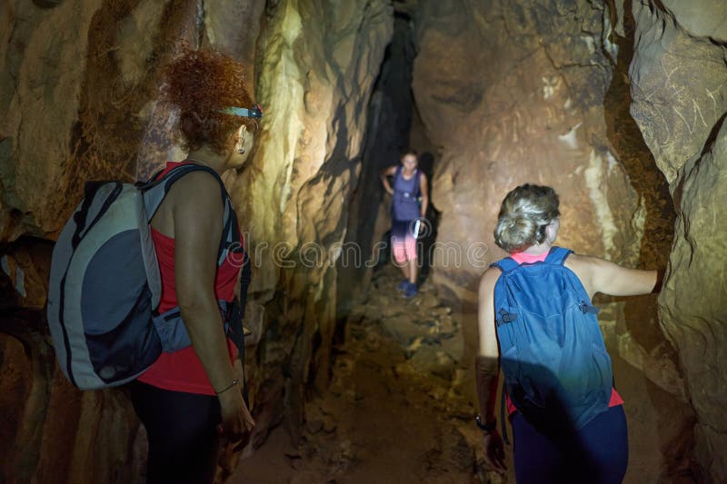 Three Ladies Exploring a Cave Stock Photo - Image of caving, dark ...