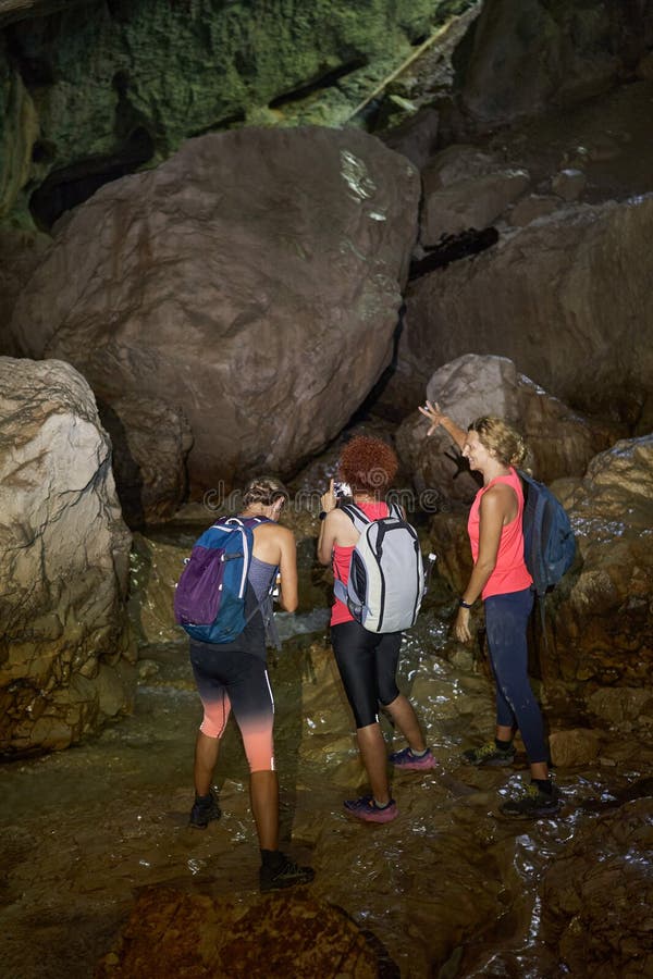 Three Ladies Exploring a Cave Stock Image - Image of group, geology ...