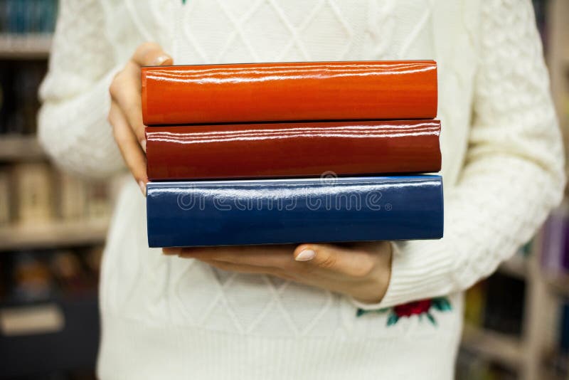 Three Large Books of Red, Orange and Blue in the Hands of a Girl Stock ...