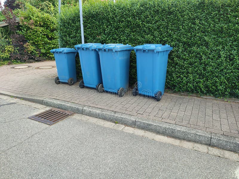 Three Large and One Small Blue Plastic Garbage Cans Stands on the Side ...