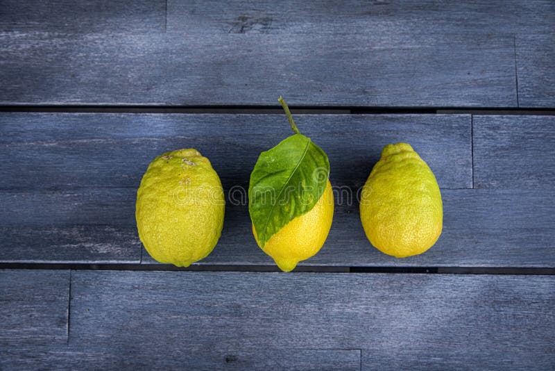 Three Lemons on a Wood Table with Two Looking the Same and the Middle ...