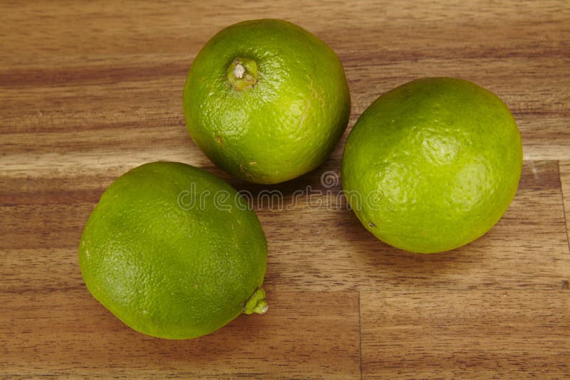 Three Limes on a Tabletop of Acacia Wood Stock Image - Image of fruit ...