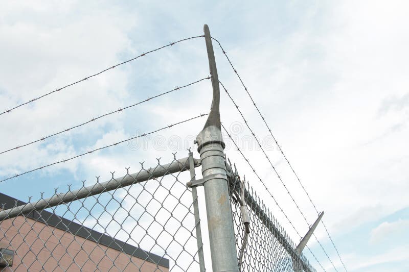 Three Lines of Barbed Wire at Top of Silver Fence Corner with Sky ...
