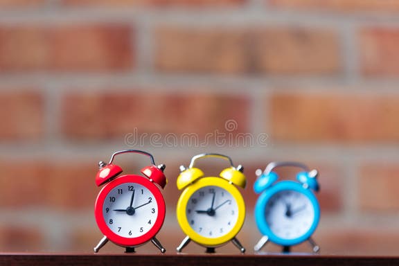 Three Little Red Alarm Clocks on Table Stock Image - Image of color ...