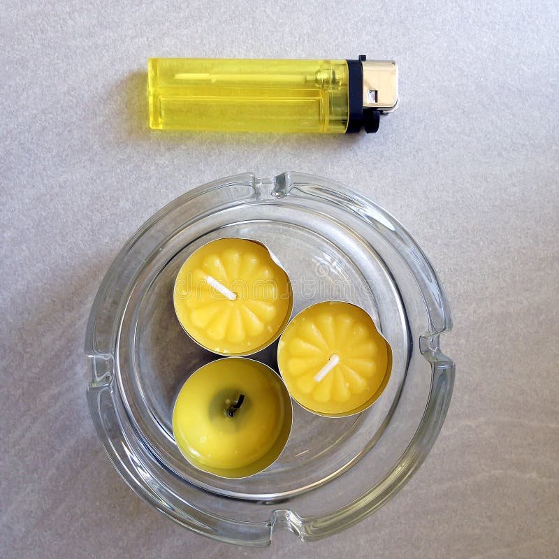 Three Little Yellow Aromatic Candles with a Yellow Lighter Stock Photo ...