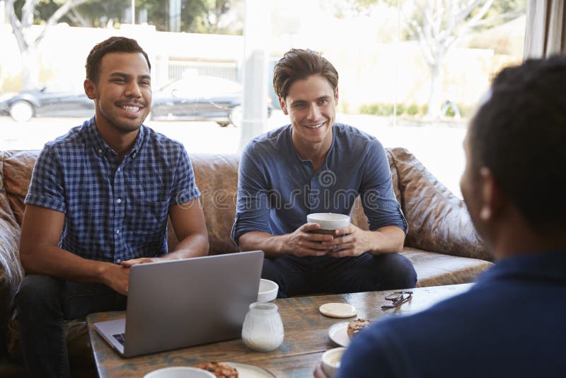 Three Male Friends Talking Over Coffee at a Coffee Shop Stock Image ...