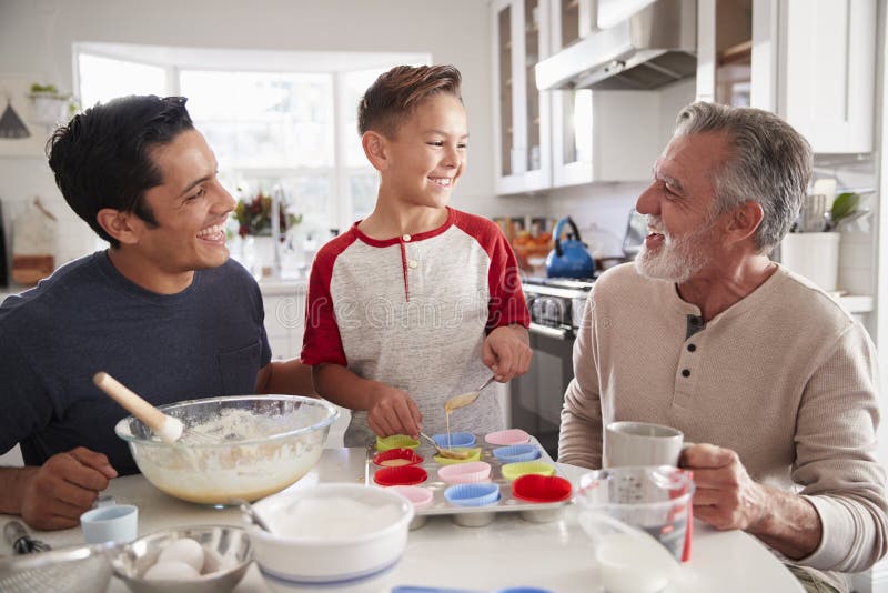 Three Male Generations of Family Making Cakes Together at the Table in ...