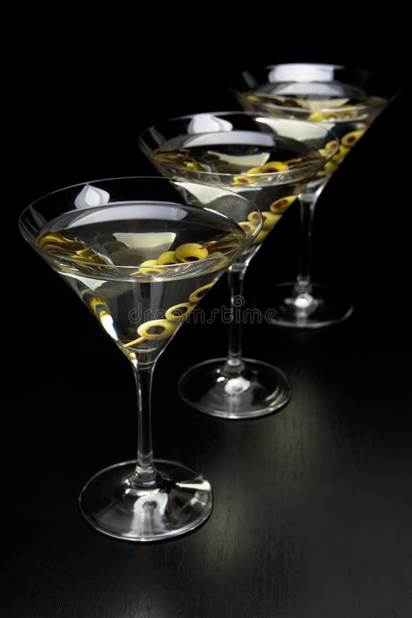 Three Martini Drinks with Olives Isolated on Black Table Stock Image ...