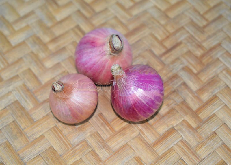 Three Medium Sized Red Colored Fresh Onion Gathered Together on a Wood ...