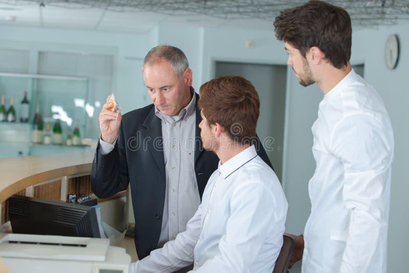 Three Men Behind Reception Desk Stock Photo - Image of suit, three ...