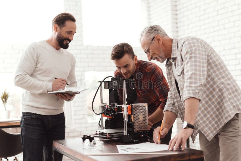 Three Men Set Up a Self-made 3d Printer. One of the Men Checks the ...