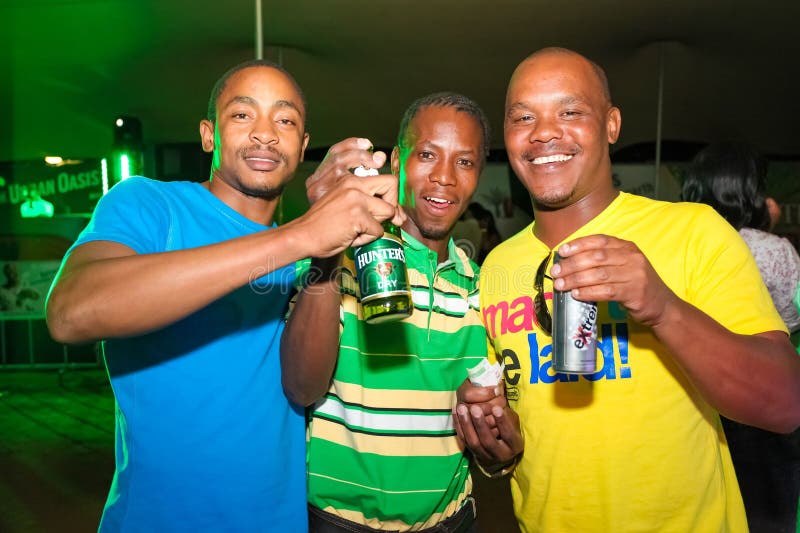 Three Men are Standing Together Drinking Beers while Smiling for the ...