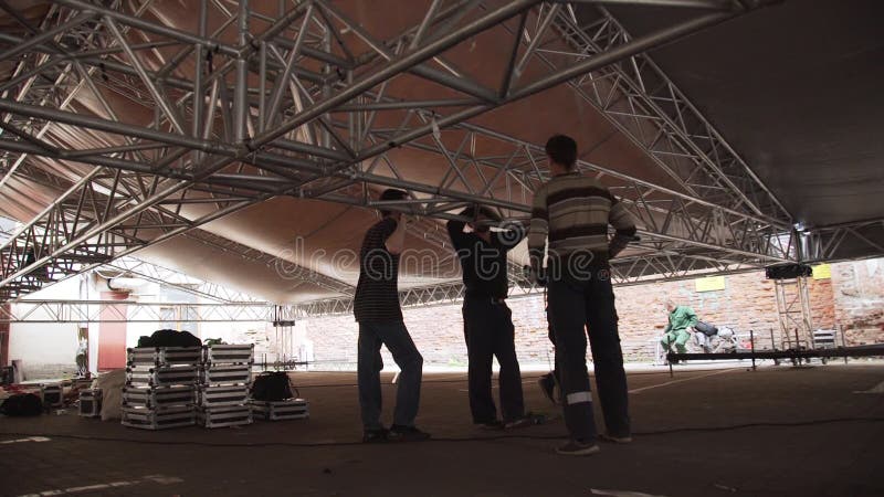 Three Men Workers Technically Prepare Stage for the Big Concert Under ...