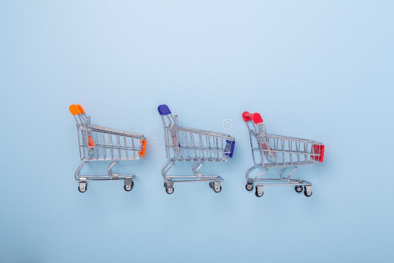 Three Mini Shopping Carts on Blue Background Top View Copy Space Stock ...