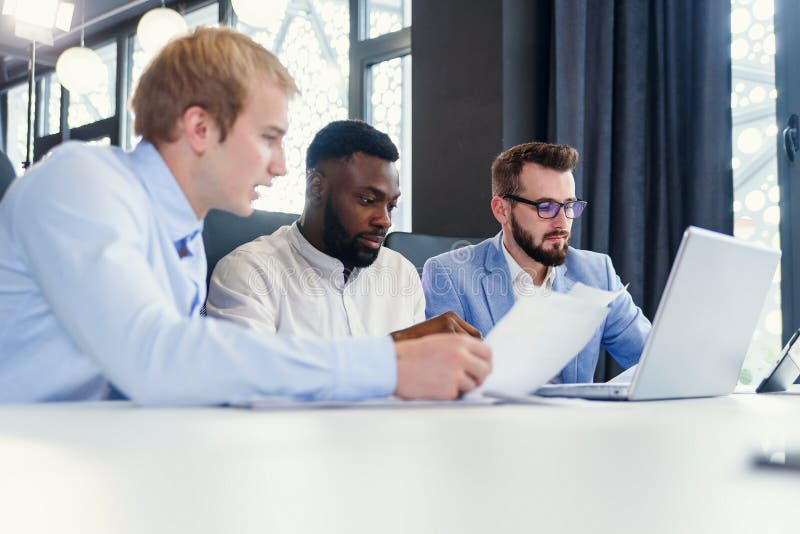 Mixed Races Coworkers Analysing Different Business Papers and Working ...