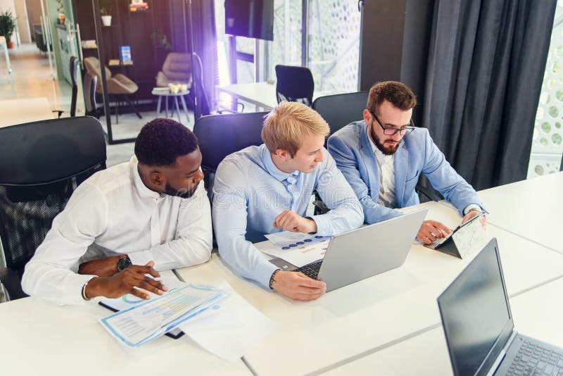 Mixed Races Coworkers Analysing Different Business Papers and Working ...