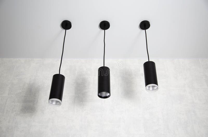 Three Modern LED Lights Hang from the Ceiling on a Wire Stock Photo ...