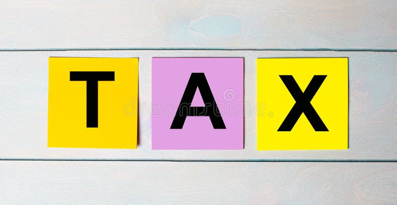 Three Multi-colored Paper Stickers with TAX Text on a Blue Wooden ...