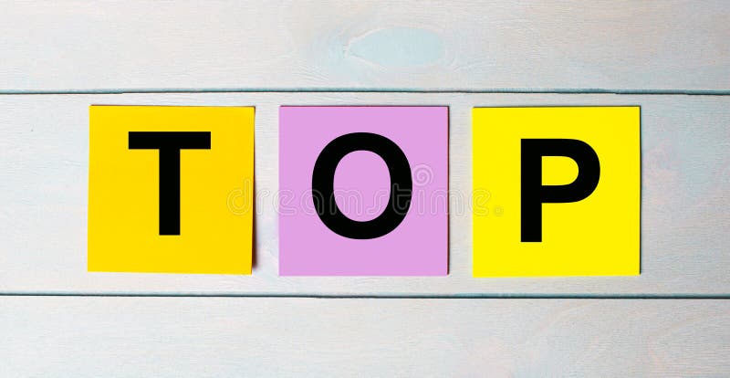 Three Multi-colored Paper Stickers with TOP Text on a Blue Wooden ...