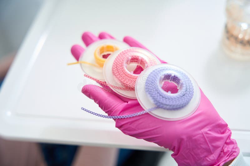 Three Multi-colored Spools of Consumables Lie in Palm of Orthodontist ...