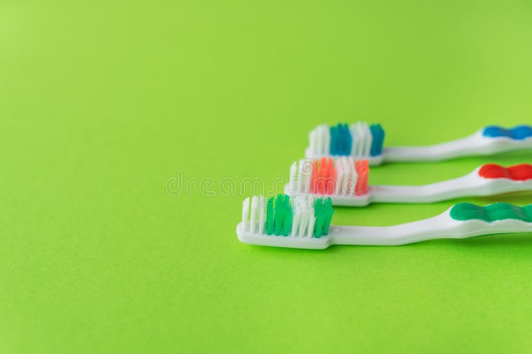 Three Multi-colored Toothbrushes on a Light Green Background. Oral Care ...
