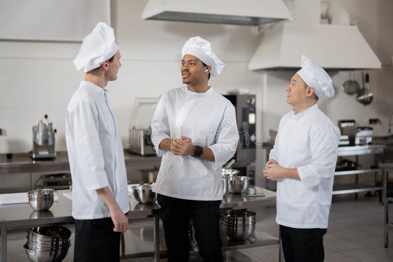 Three Multiracial Chef Cooks Talk while Standing Together during a ...