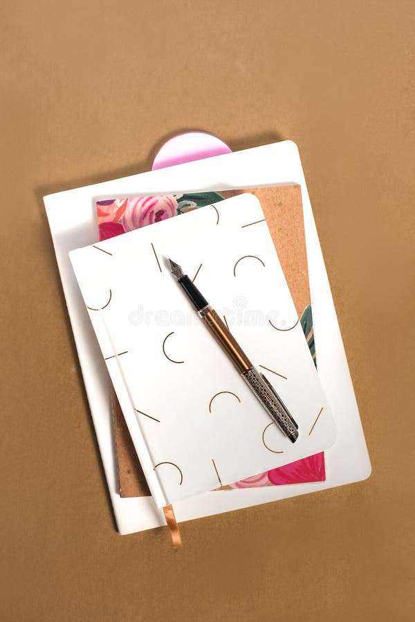 Three Notebooks on Golden Brown Background with Ink Pen and Copy Spaces ...