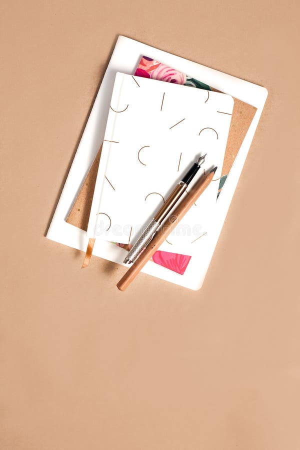 Three Notebooks on Golden Brown Background with Ink Pen and Copy Spaces ...