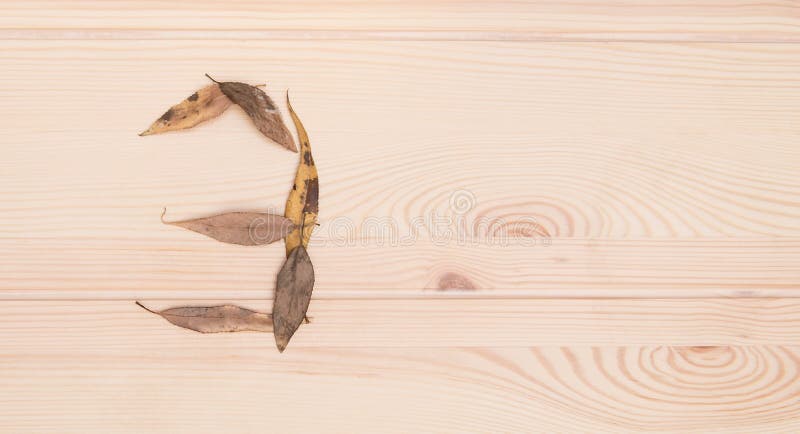Three. Three Number Folded from Autumn Leaves on a Light Wooden ...