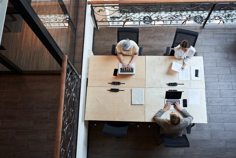 Three Office Workers Sitting at a Desk Working Hard Stock Photo - Image ...