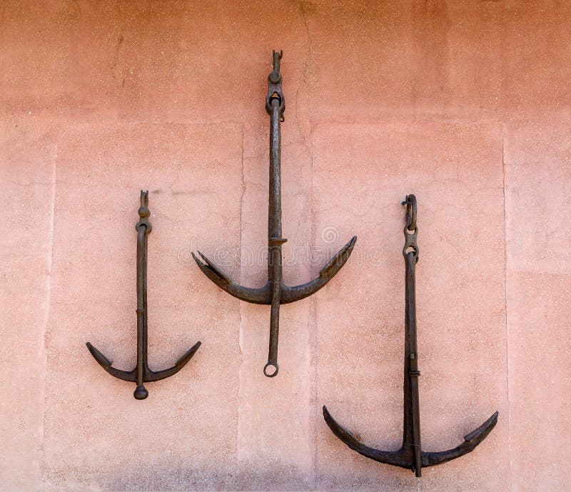 Three Old Rusty Anchor Hanging on the Plastered Wall Burgundy Stock ...