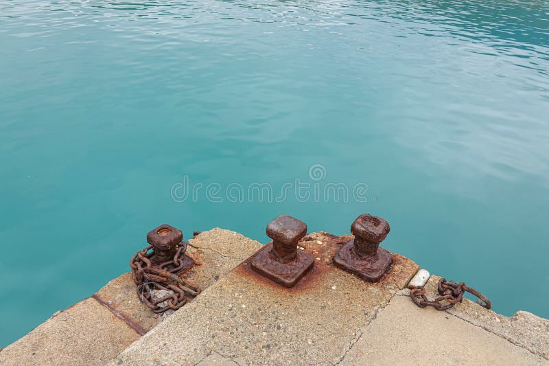 Three Old, Rusty Mooring Posts are Lined Up Against a Serene Harbor ...