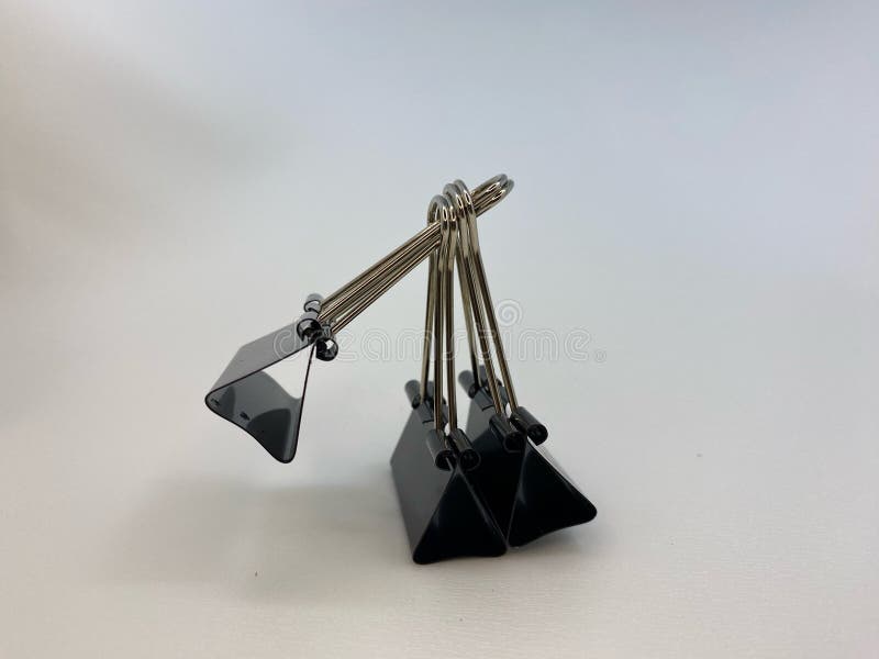 Three Paper Clips Shaped Like an Illustration of a Scale that is Biased ...