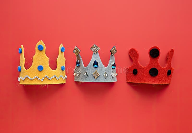 Three Paper Crowns Displayed on a Vibrant Red Background Stock Image ...