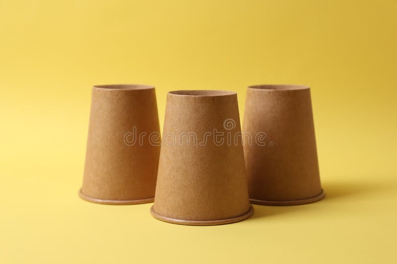 Three Paper Cups on Yellow Background. Thimblerig Game Stock Image ...