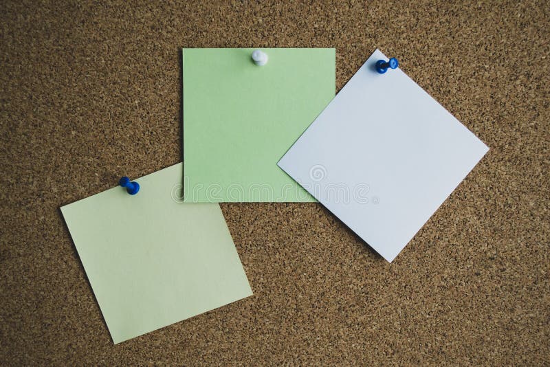 Three Paper Notes Green, White and Yellow Color on a Cork Board ...