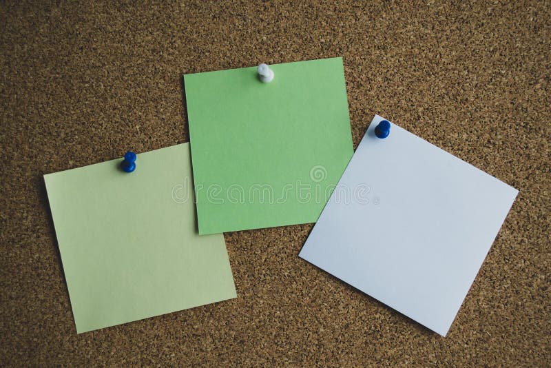 Three Paper Notes Green, White and Yellow Color on a Cork Board ...