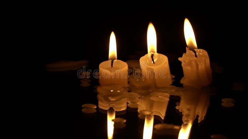 Three Paraffin Candles Burn in a Row on a Black Background with ...
