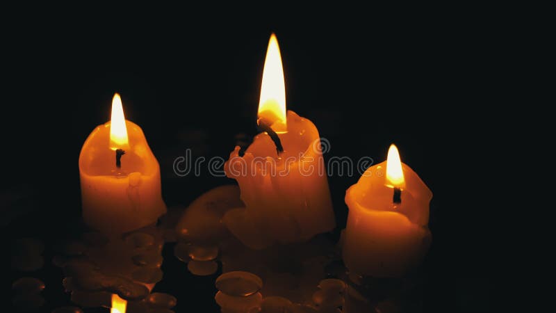 Three Paraffin Candles Burn in a Row on a Black Background with ...