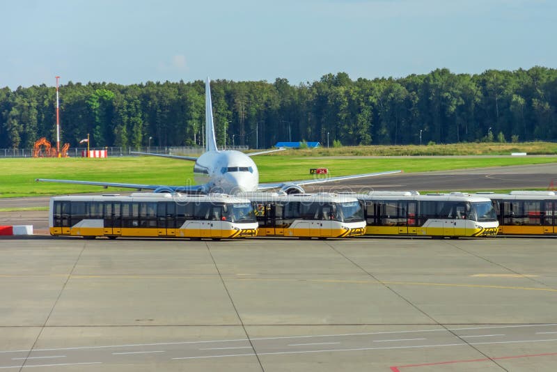 Three Passenger Buses in Front of the Plane on the Apron at the Airport ...